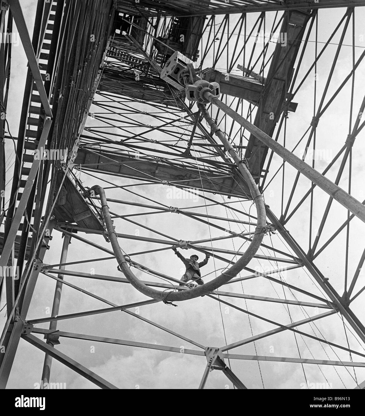 A worker climbs a derrick Stock Photo - Alamy
