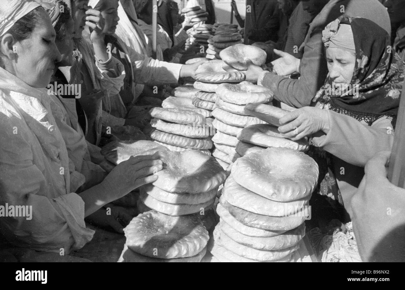 A Tajik woman sells nana flat bread at a market Stock Photo - Alamy