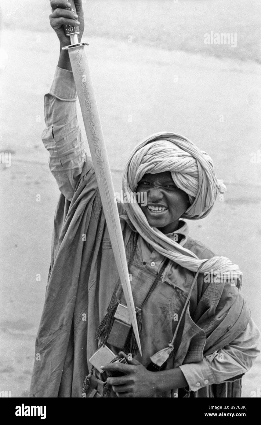 Seller of souvenirs showing a Tuareg dagger Stock Photo - Alamy