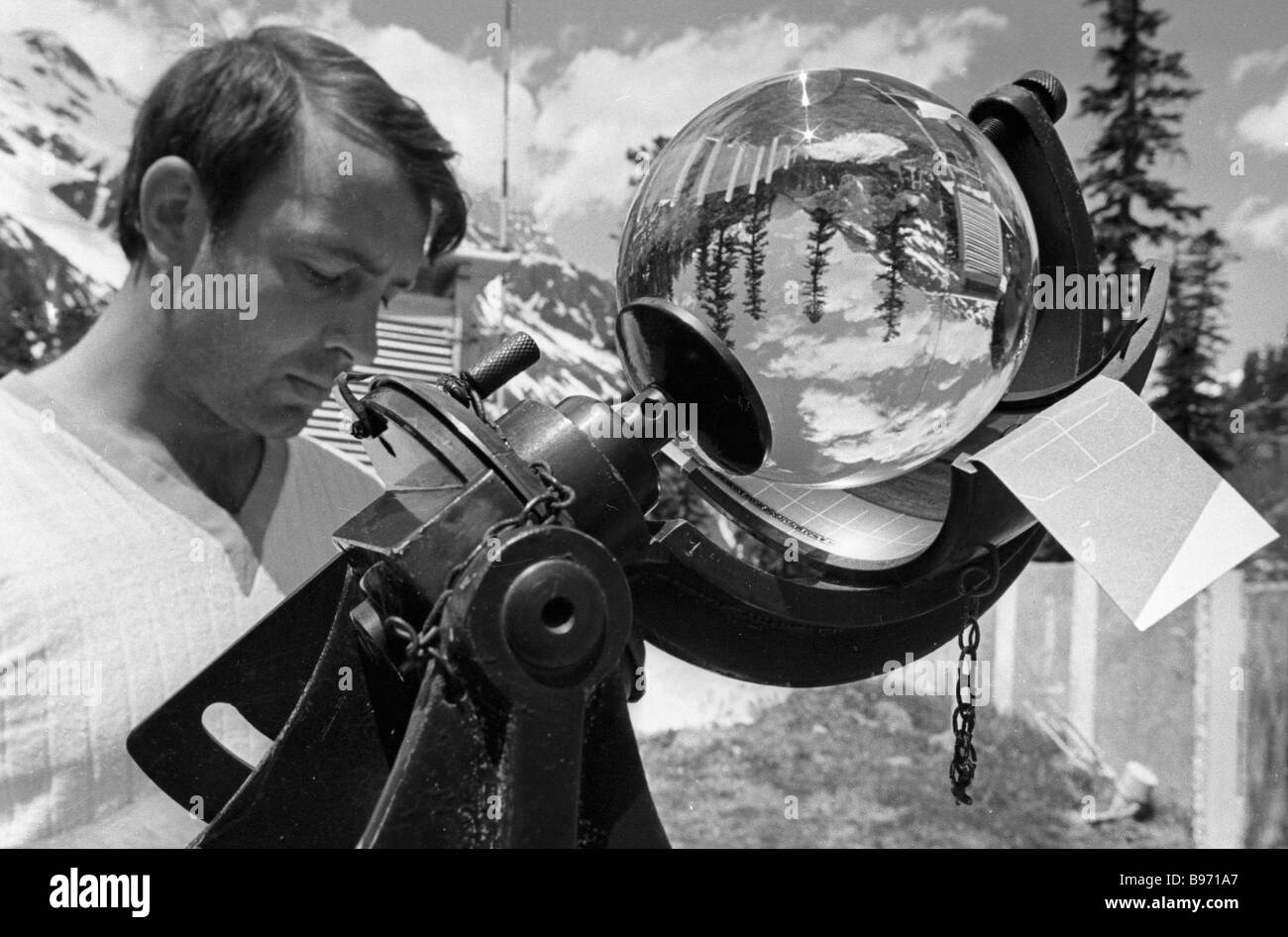Scientist studying the solar activity with the help of a heliograph ...