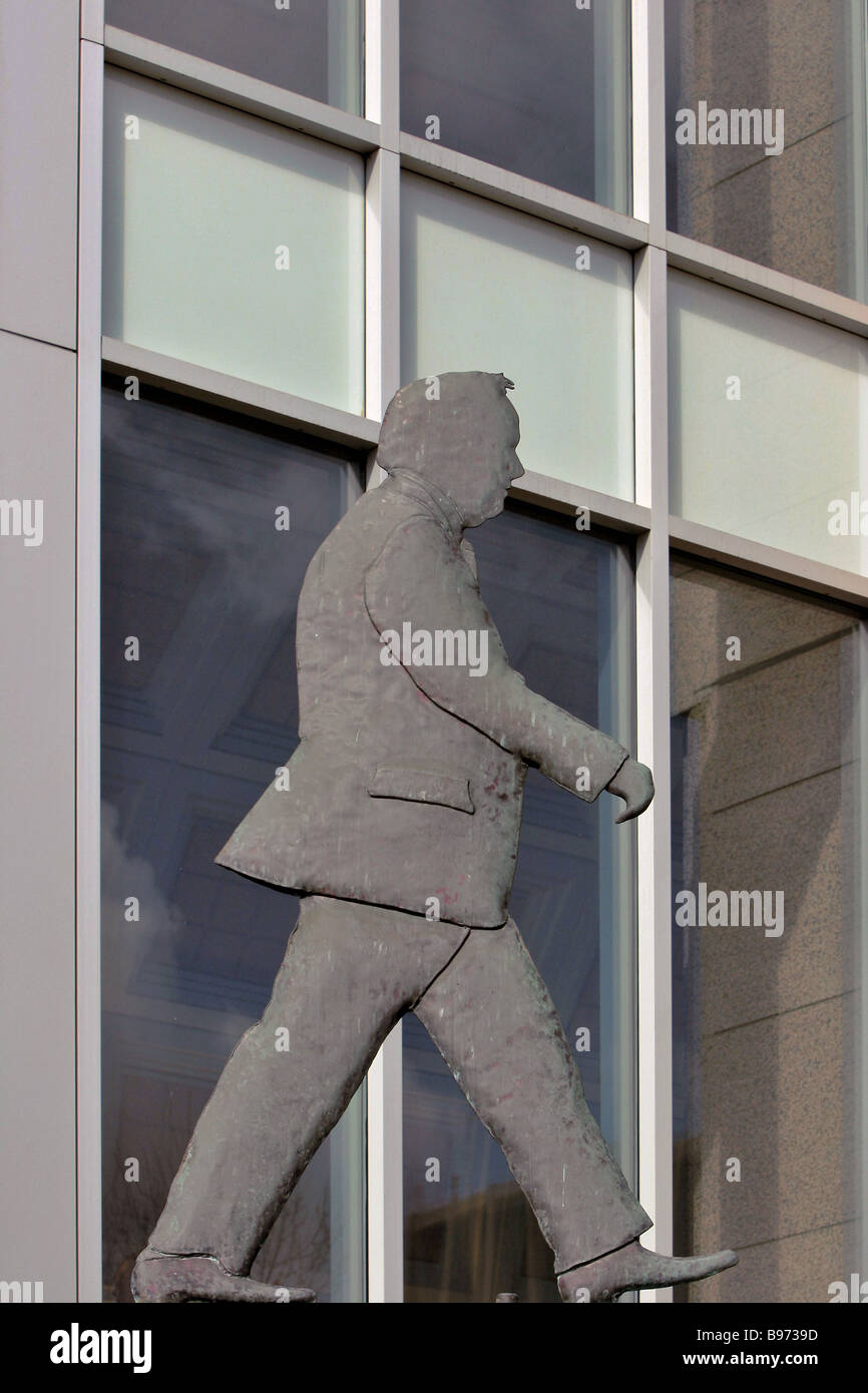 A statue of a man walking past a building Stock Photo - Alamy
