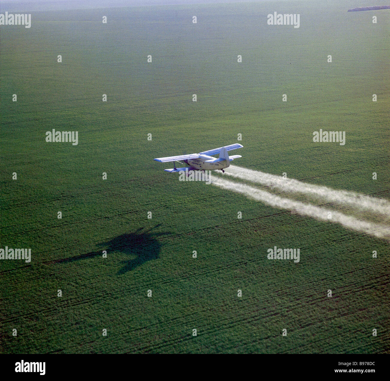 A crop-duster spraying fertilizer over grain crops in the Alma-Ata ...