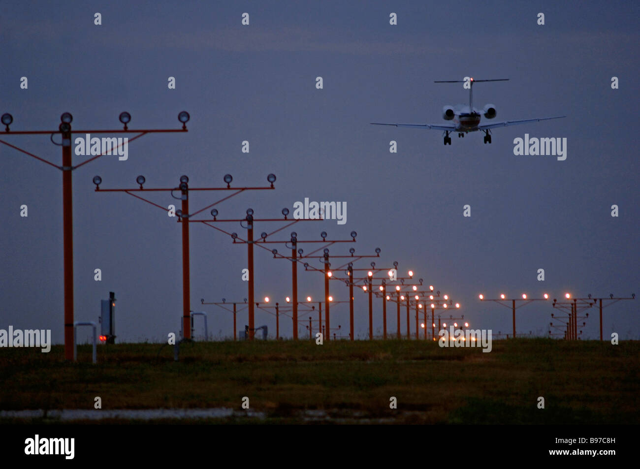 Jet airliner on approach over runway lights at DFW International ...