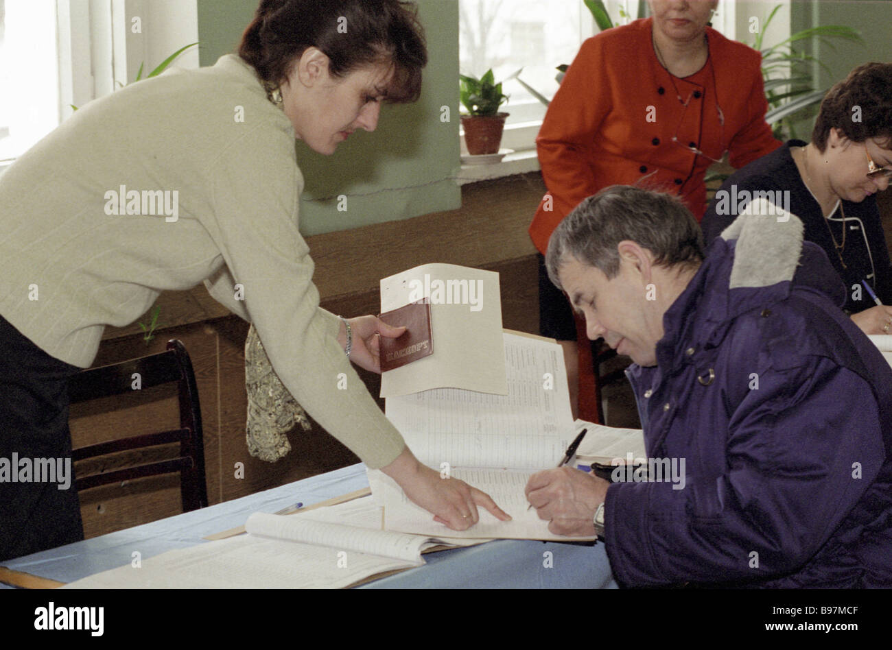 A Muscovite signs a voting ballot at the polling station 1412 of Moscow ...