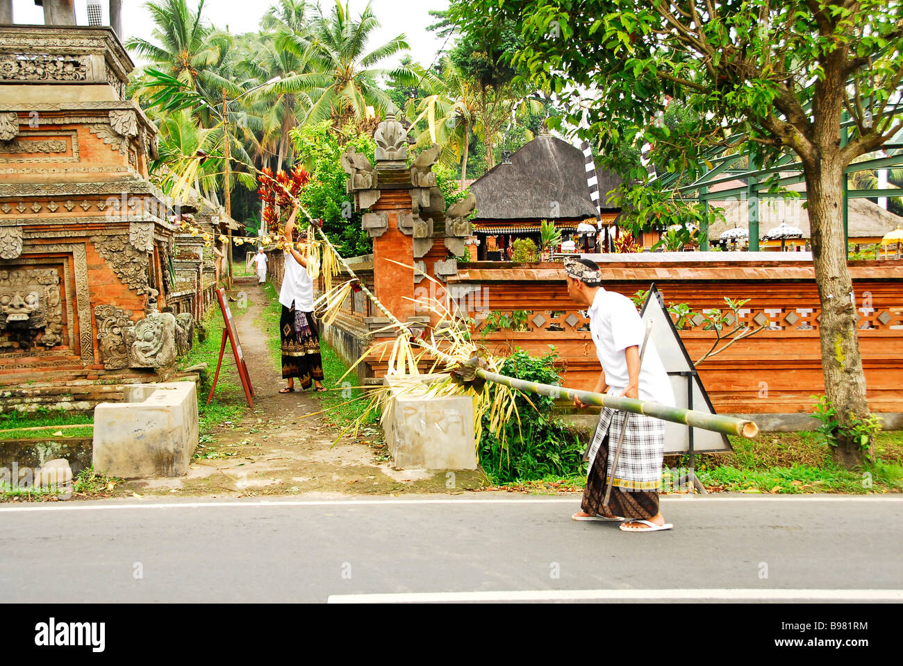 Balinese folks preparing to raise up decorated bamboo pole during ...