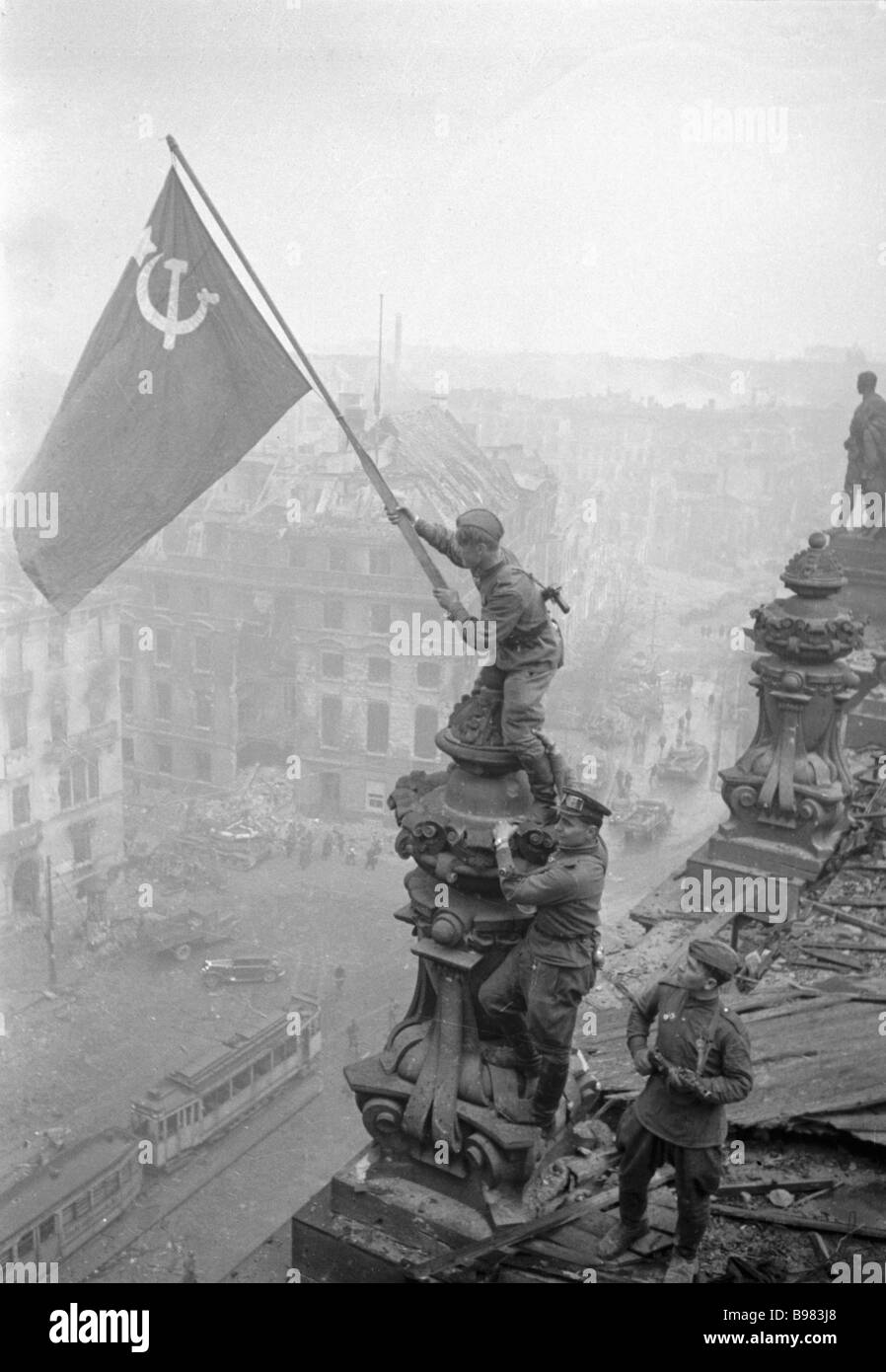 A soldier raising the Victory banner on the roof Stock Photo - Alamy