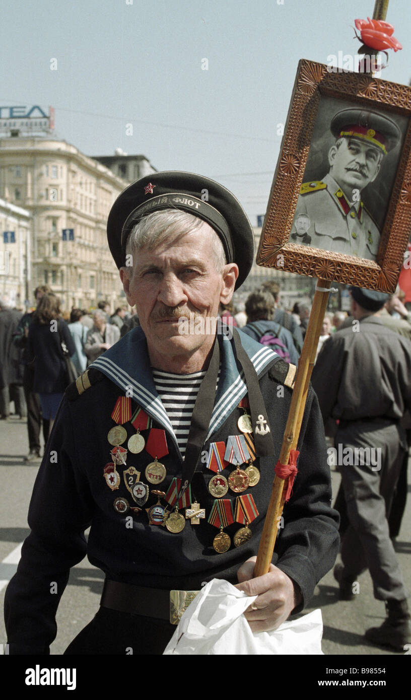A war veteran with medals and a Stalin portrait at an opposition rally ...