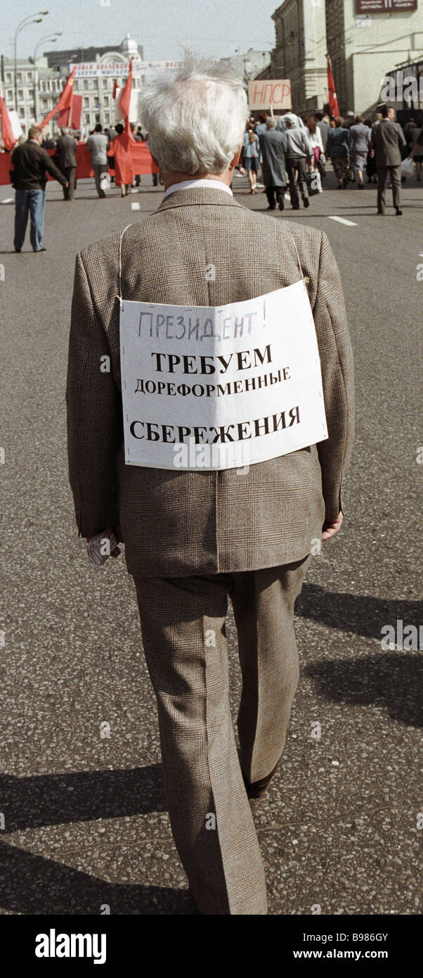 A participant in an opposition rally walking with a placard on his back ...