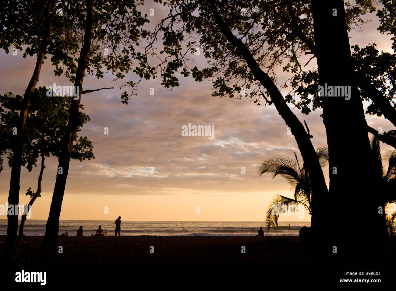 Family winding down a day at the beach watching sunset in Dominical ...