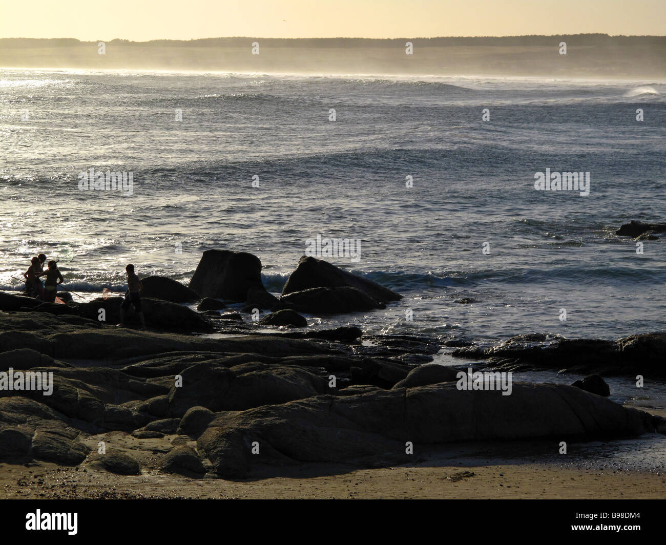 The rocky coast at the beach in Uruguay during the sunset Stock Photo ...