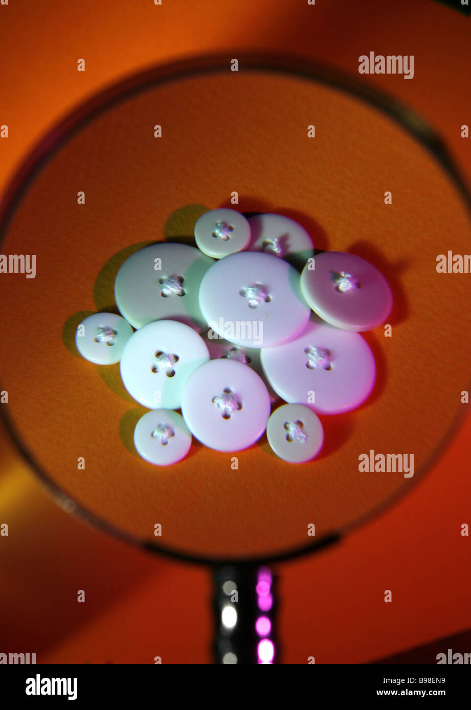 a stack of buttons viewed throgh a magnifying glass Stock Photo - Alamy