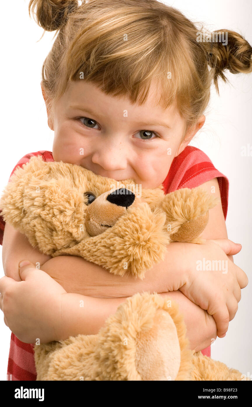 Little girl hugging a teddy bear,white background Stock Photo - Alamy