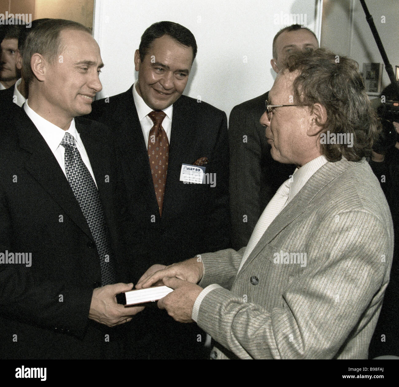 Writer and playwright Edward Radzinski right gives his book to Russian Prime Minister Vladimir ...