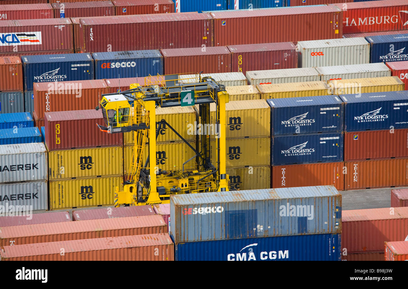 Shipping containers with straddle carrier Stock Photo - Alamy