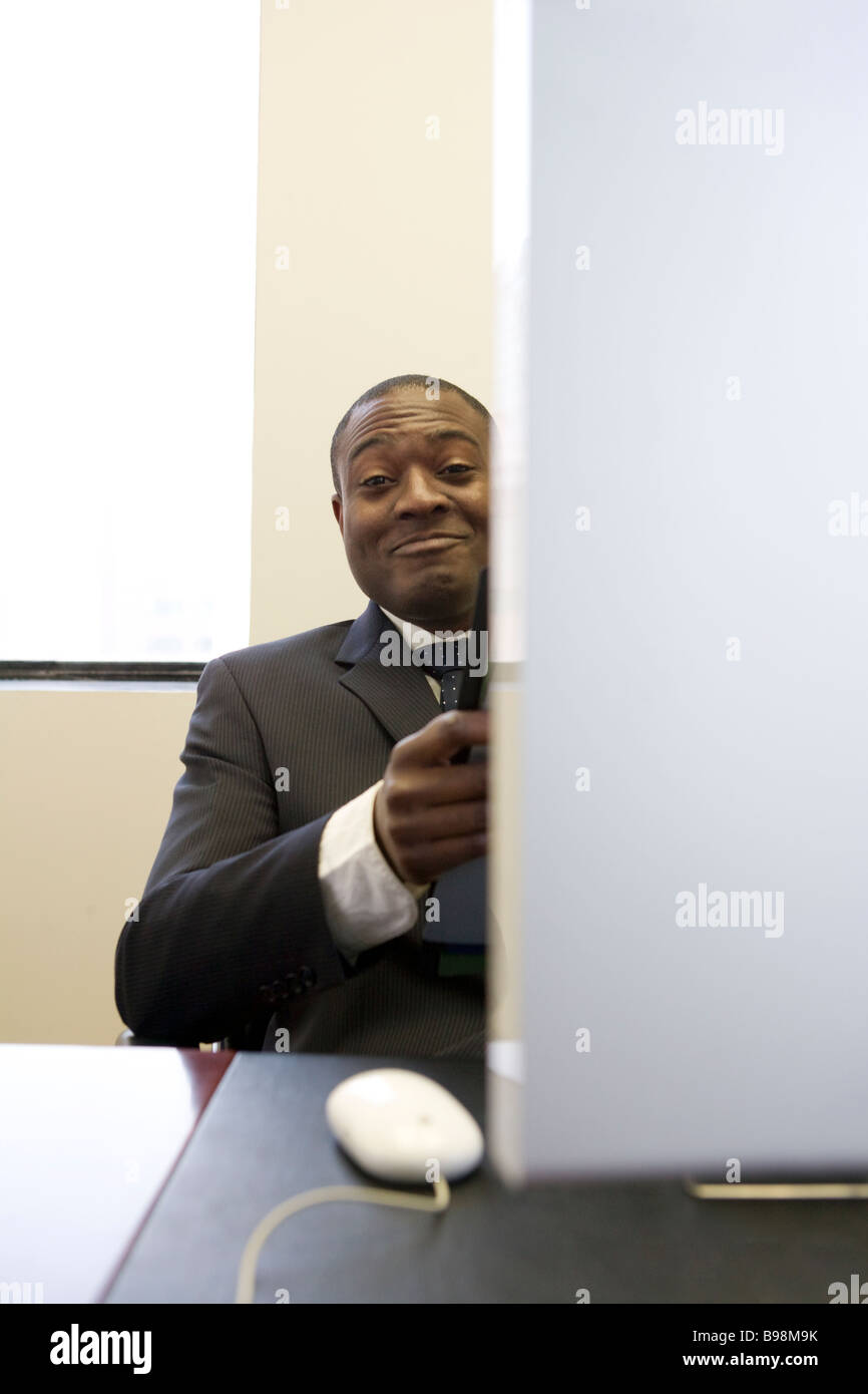 Businessman behind computer monitor Stock Photo - Alamy