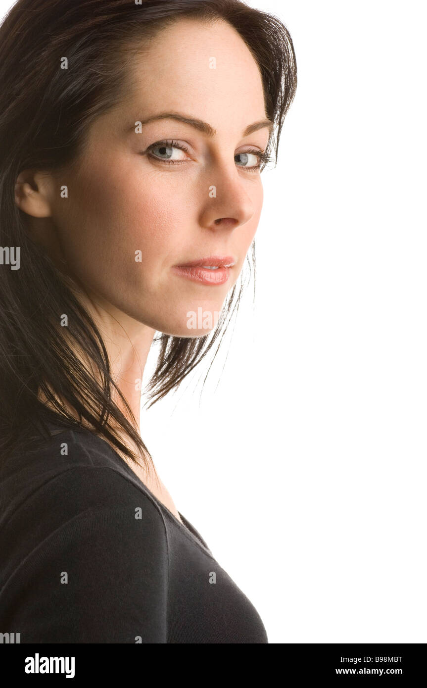 Woman looking over her shoulder with serious expression,studio shot ...