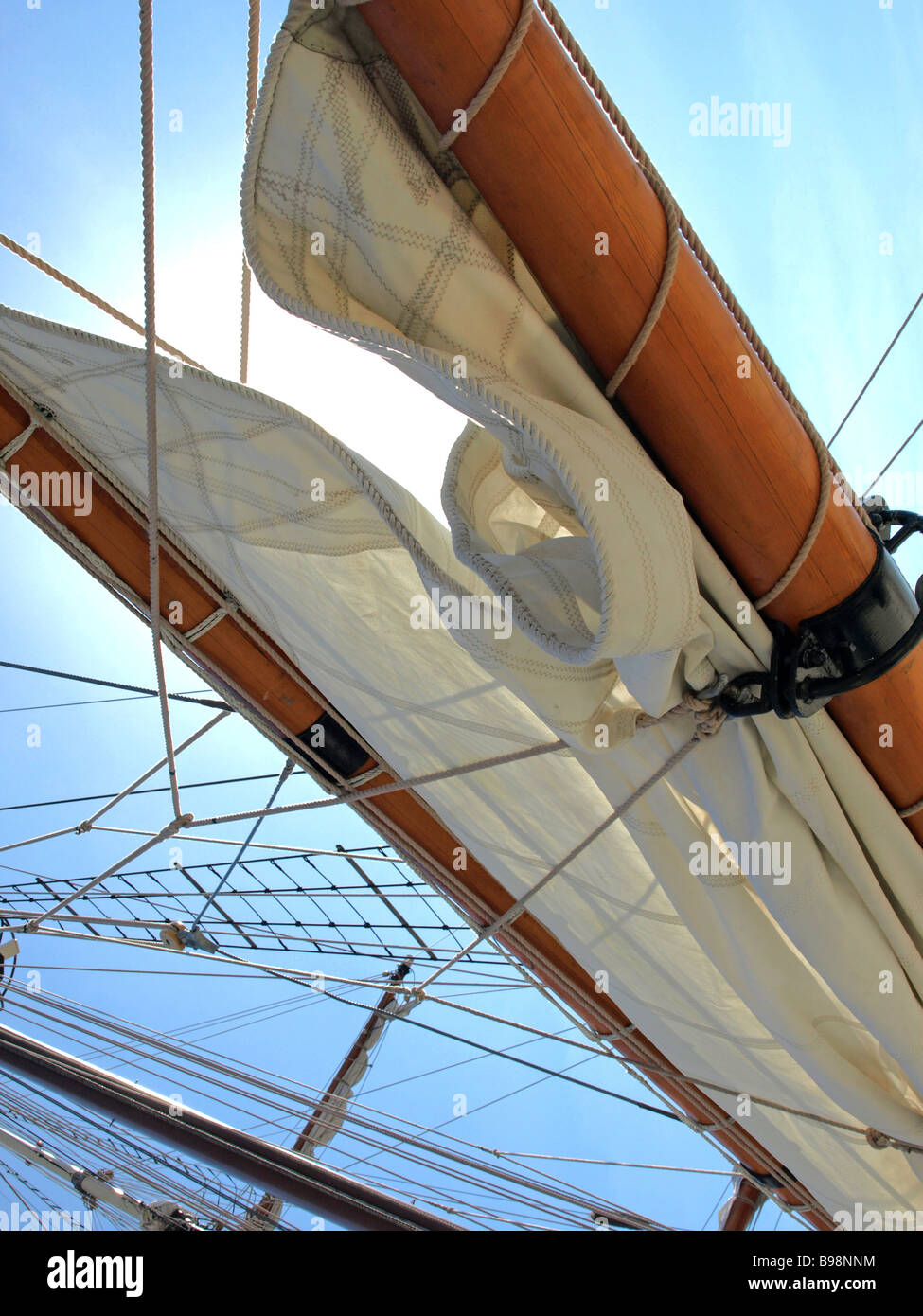 closeup view of furled canvas on a tall-ship with yardarm and rigging ...