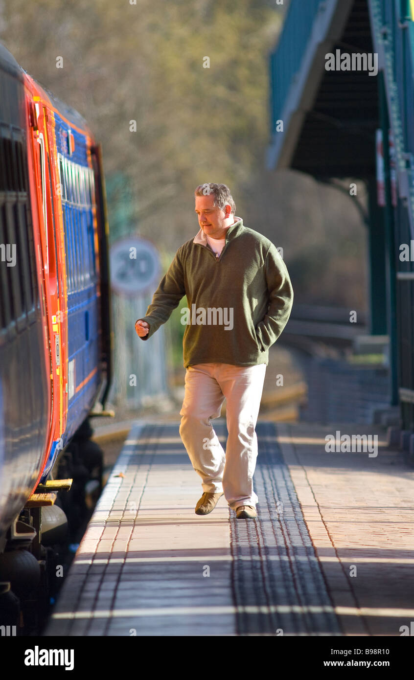 Man boarding a commuter train at a local train station Stock Photo - Alamy