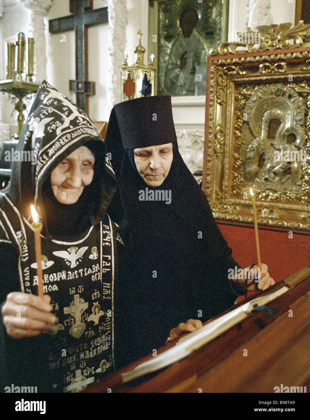 Nuns reading a psalm book in the church of the Bogoyavlensky ...