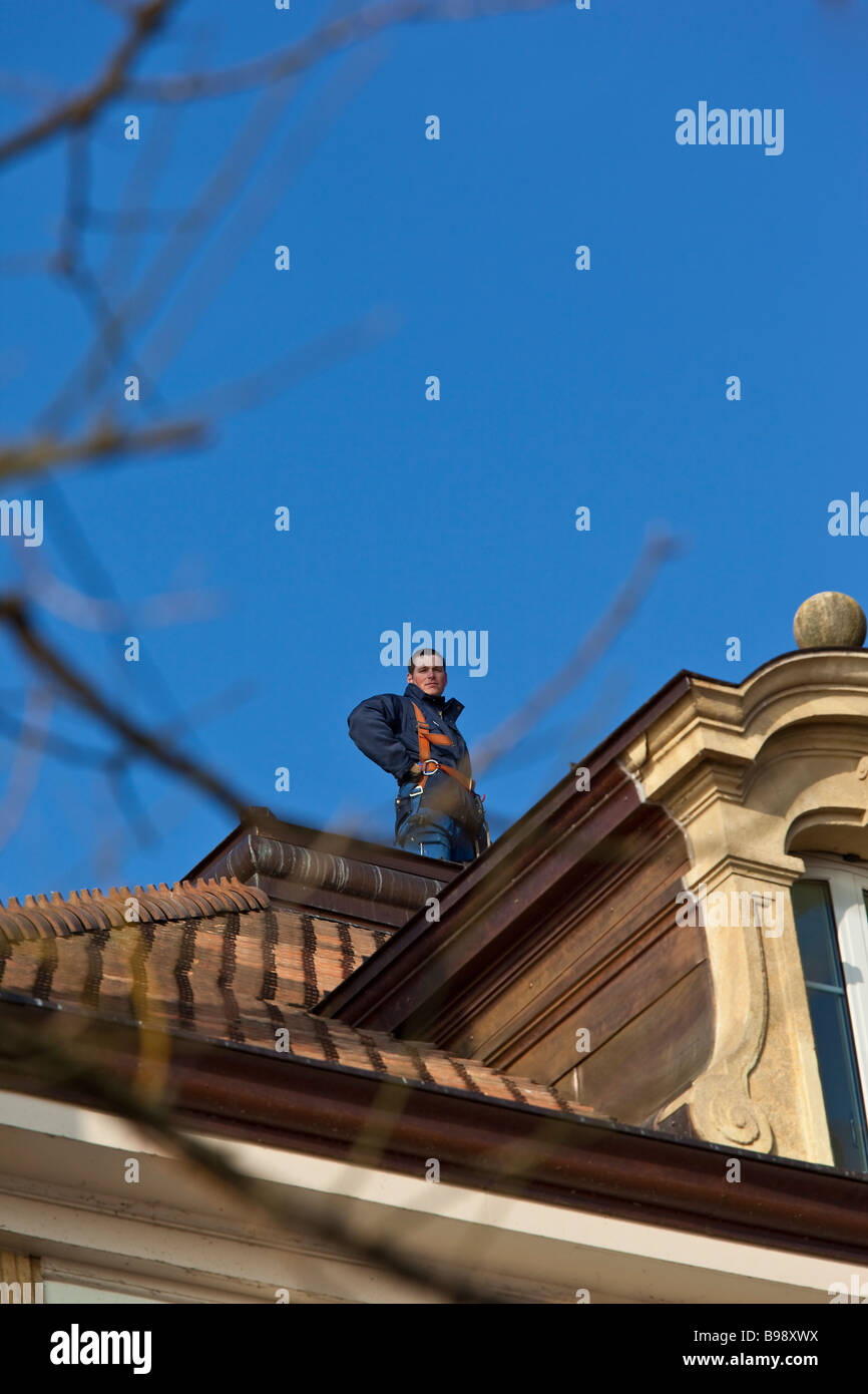 Construction worker standing on top of building looking down at the ...