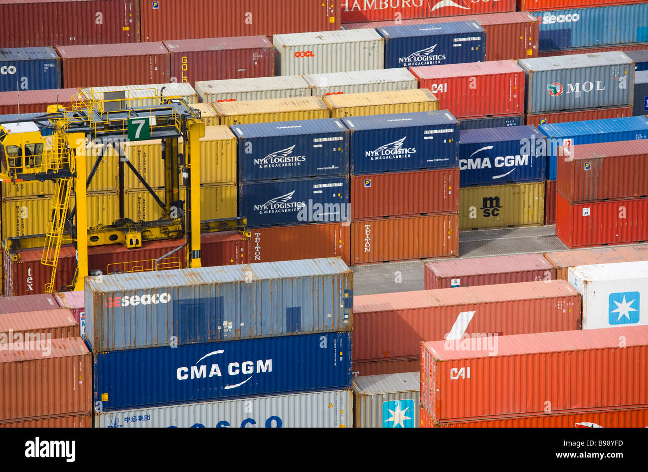 Shipping containers with straddle carrier Stock Photo - Alamy