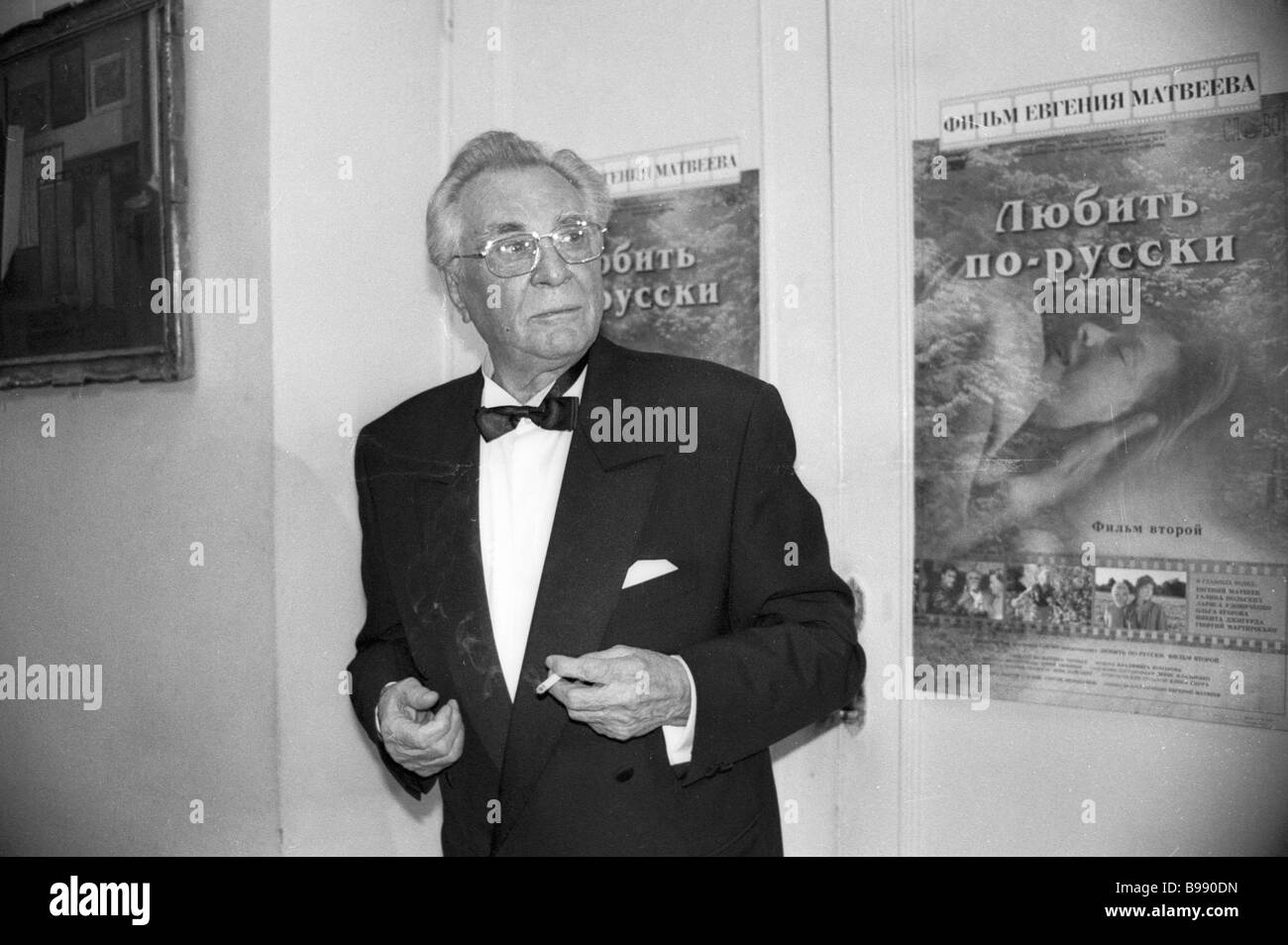 Actor and film director Yevgeny Matveev admires poster of his film Love ...