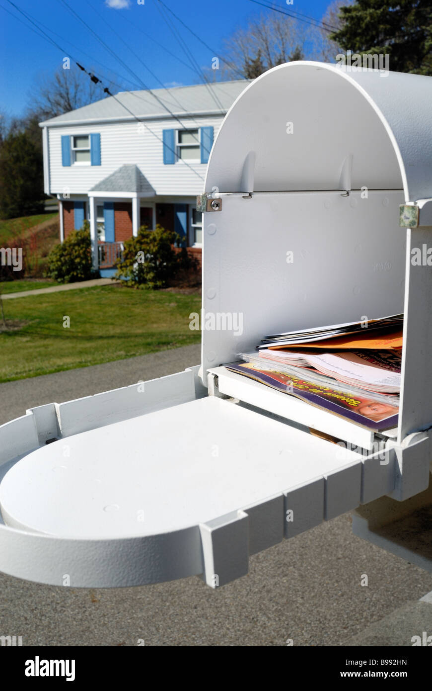 An open mailbox with mail inside with a house in the background Stock ...
