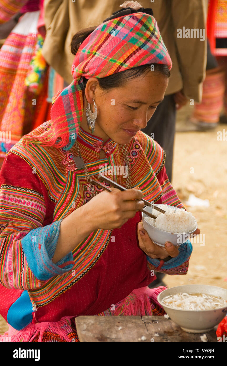colorful Flower Hmong woman eating lunch in the market in Cau Son near ...