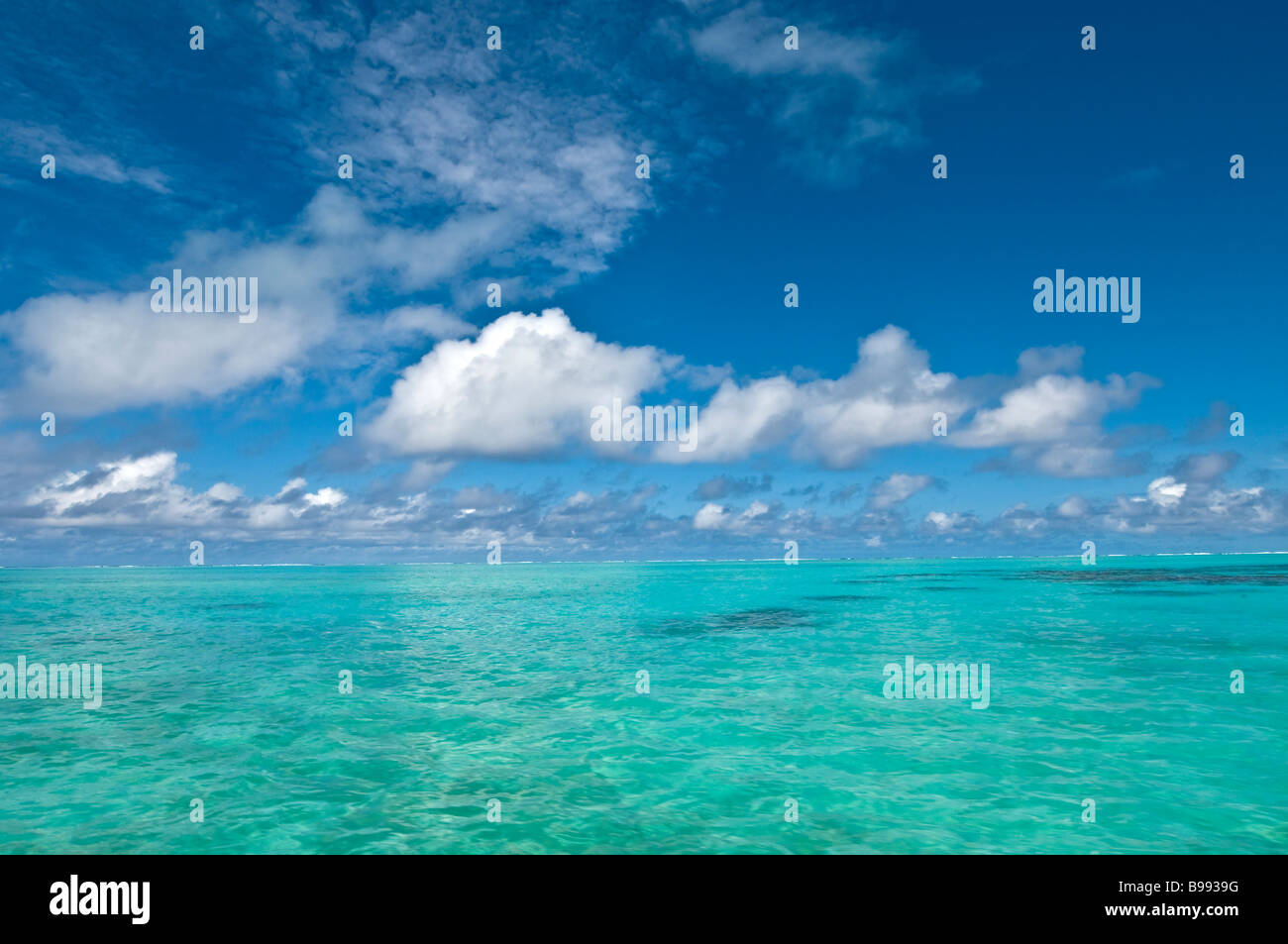Emeral Green shallow sea meets blue sky just off Aitutaki in the Cook ...