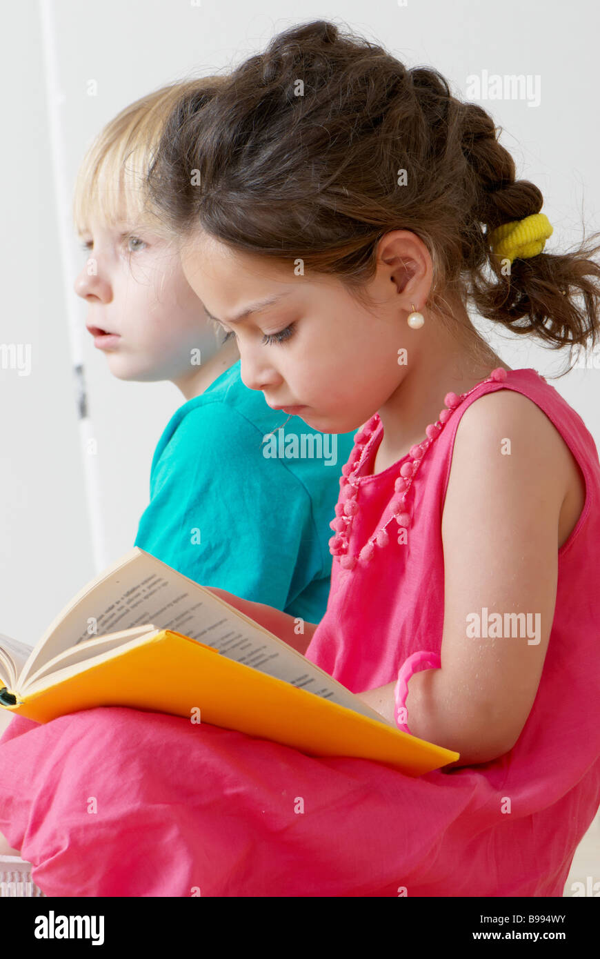 Children in a kindergarten The girl reading book Stock Photo - Alamy