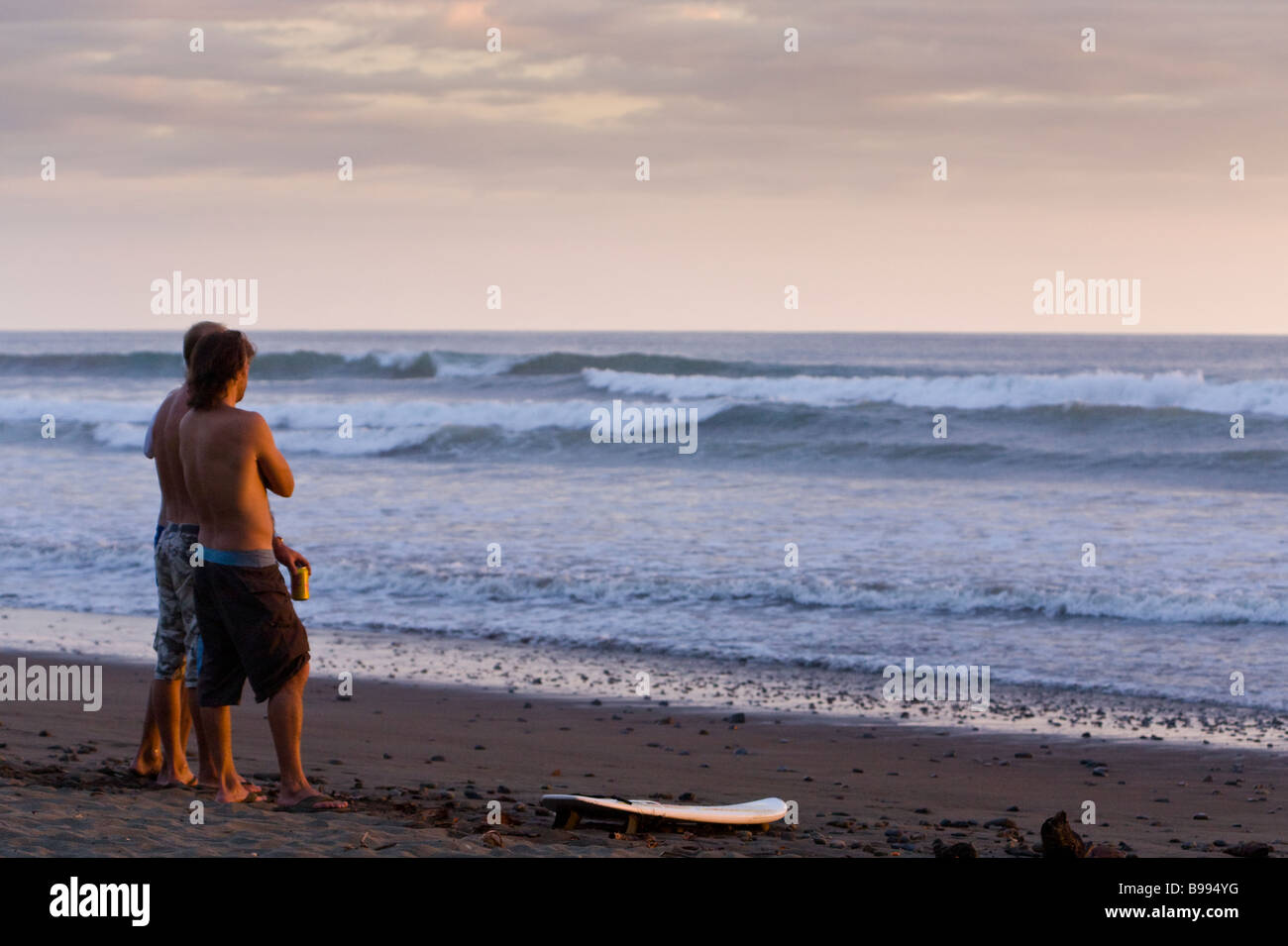 Surfers watching sunset in Dominical, Costa Rica Stock Photo - Alamy