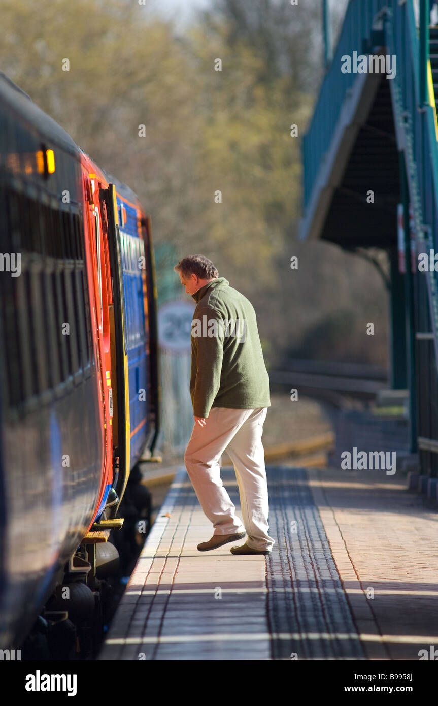 Man boarding a commuter train at a local train station Stock Photo - Alamy