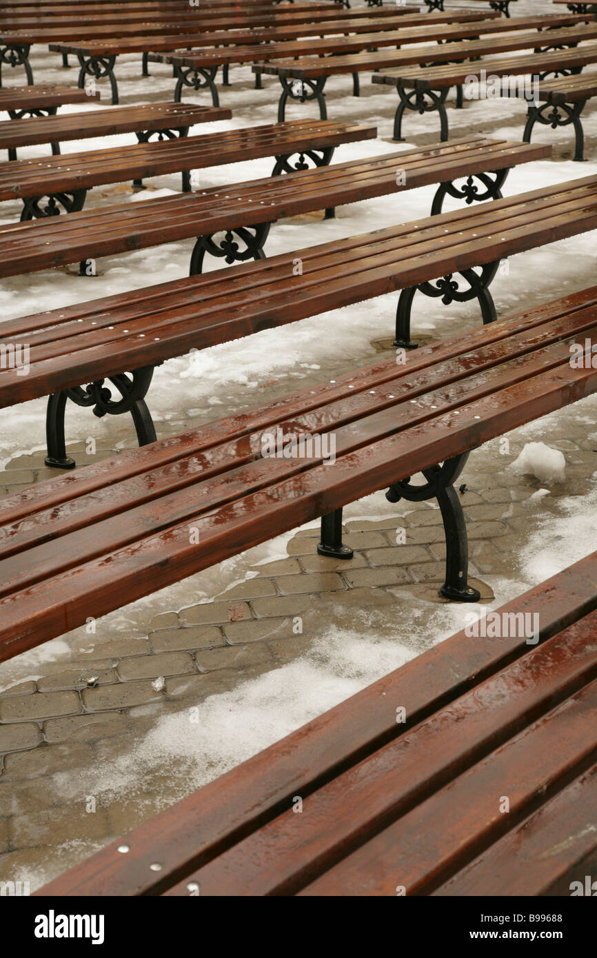 Rows of empty wooden benches in winter Stock Photo - Alamy