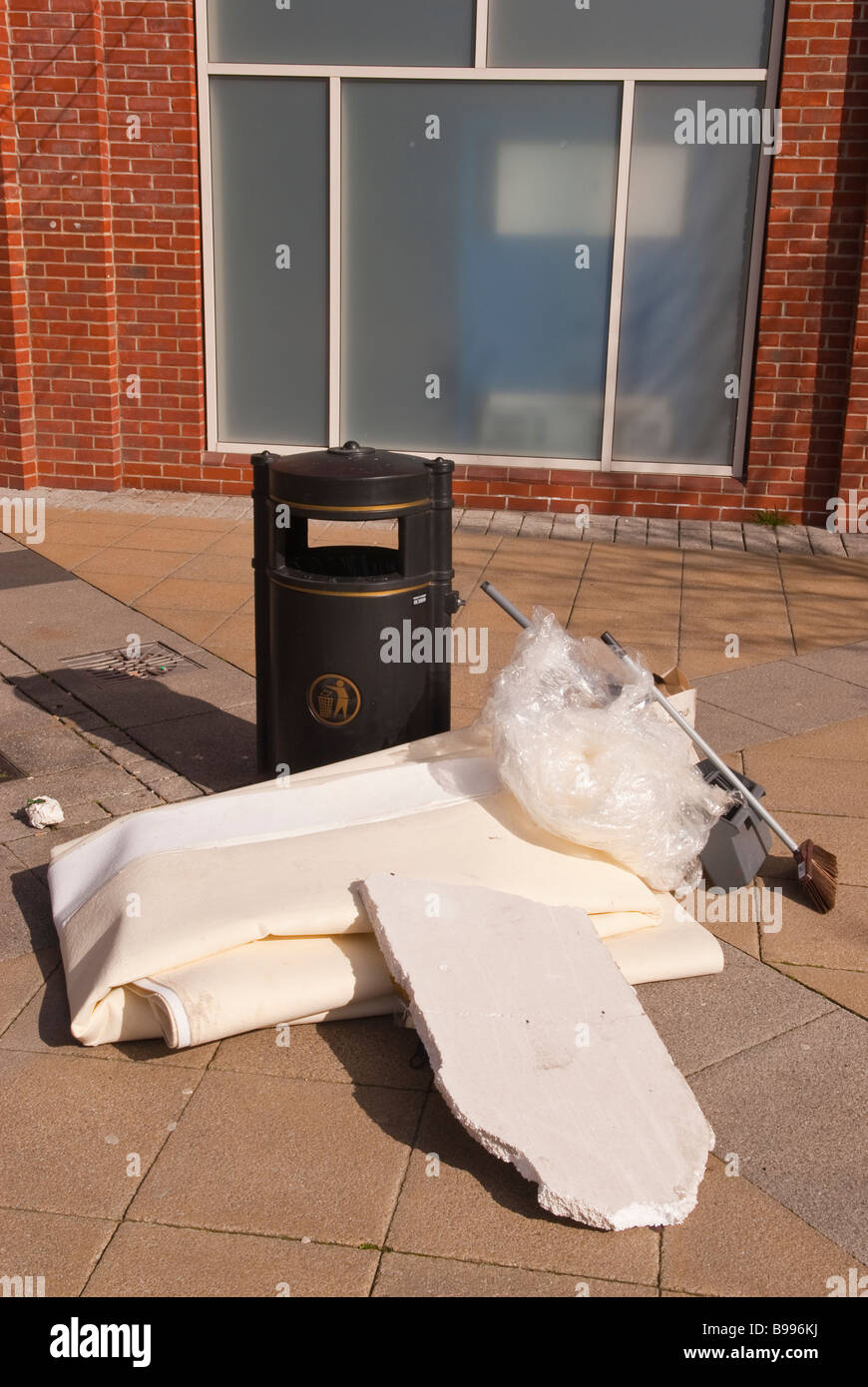 Untidy rubbish bin with trash dumped next to it Stock Photo - Alamy
