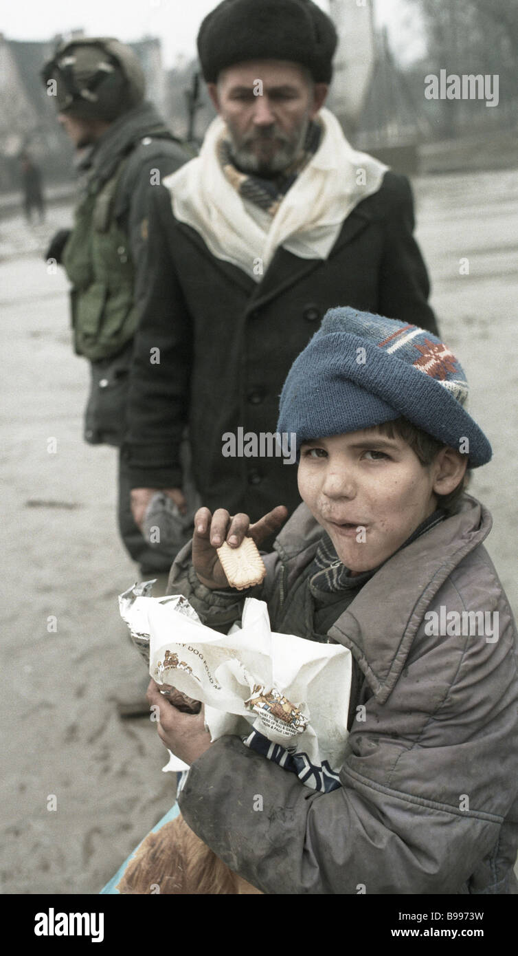 A Chechen boy enjoying the sweets presented by Russian servicemen Stock ...
