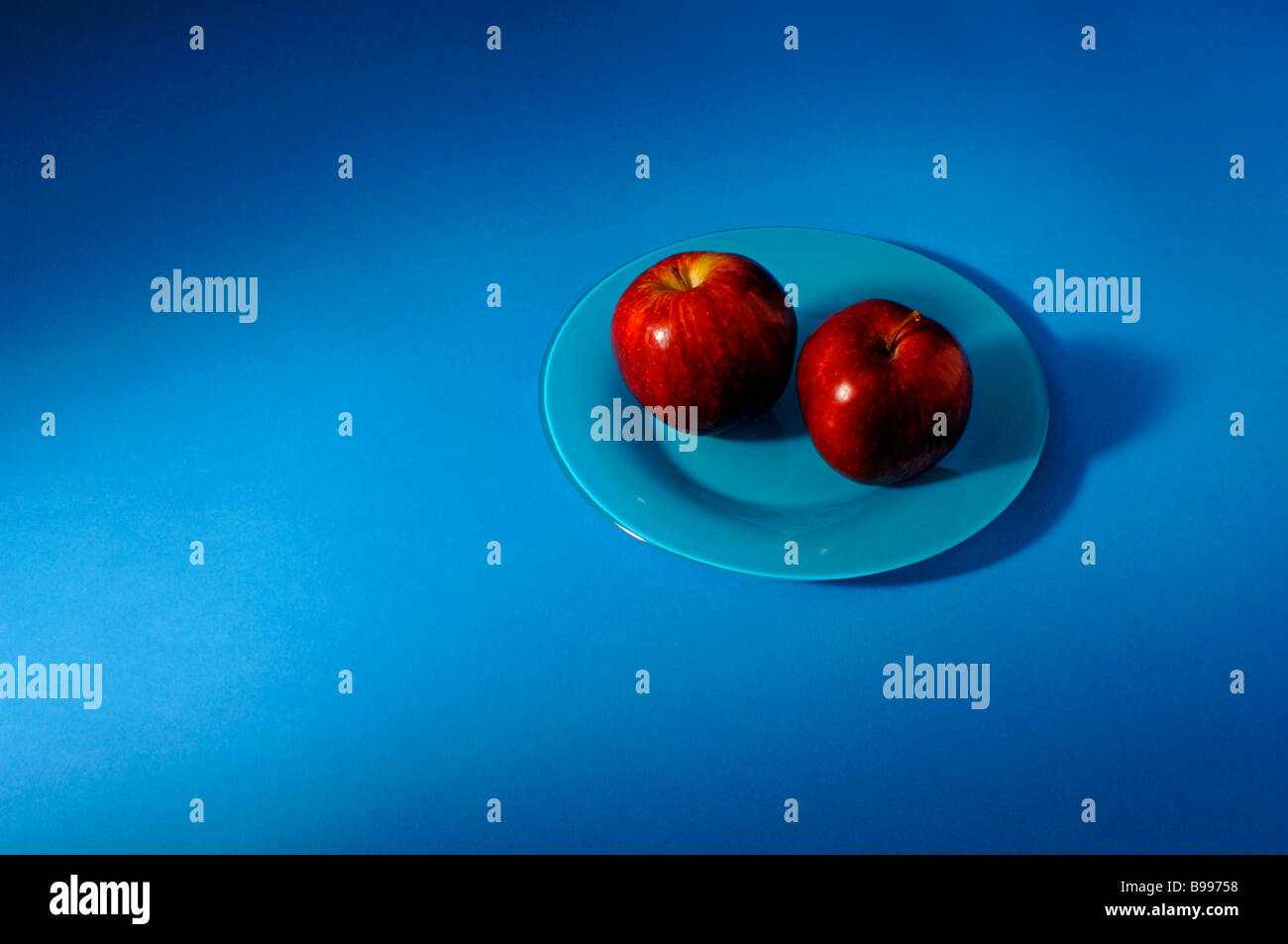 Bright red apples on clean blue set with blue plat Stock Photo - Alamy