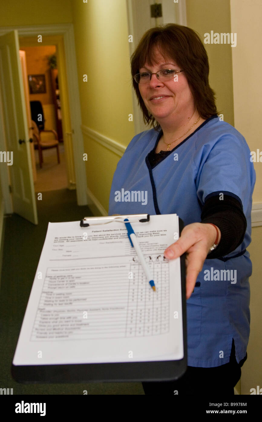 Woman, receptionist at doctor's office handing patient form on ...