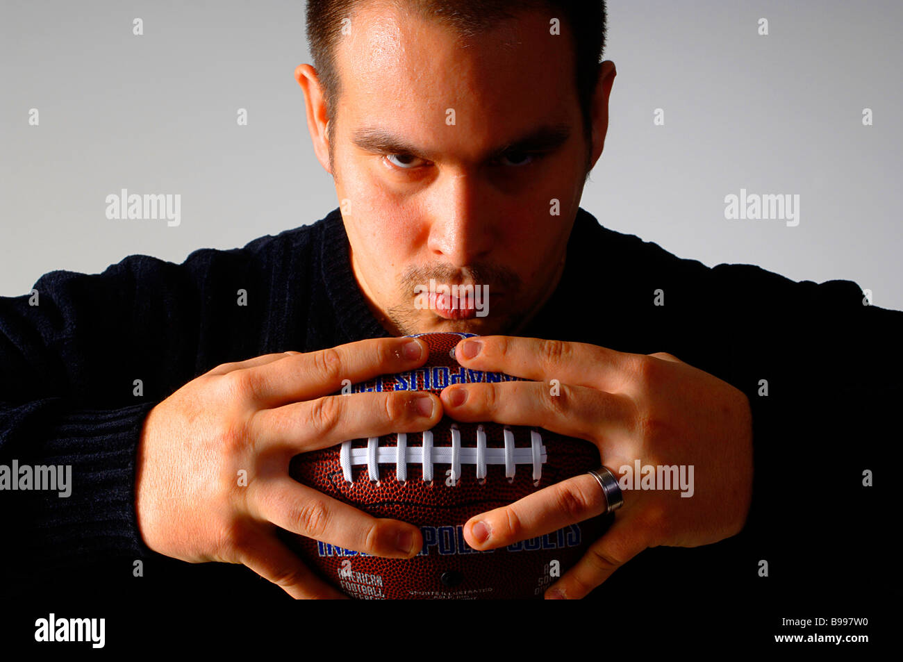 Bulked up muscular athlete posing with football Stock Photo - Alamy