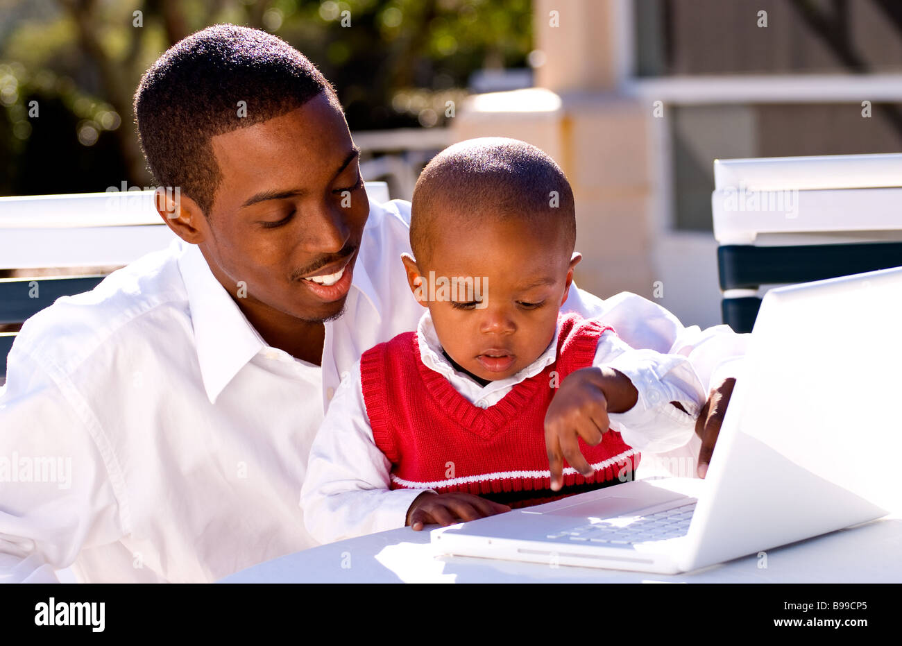 Attractive black African American father with young boy playing with ...