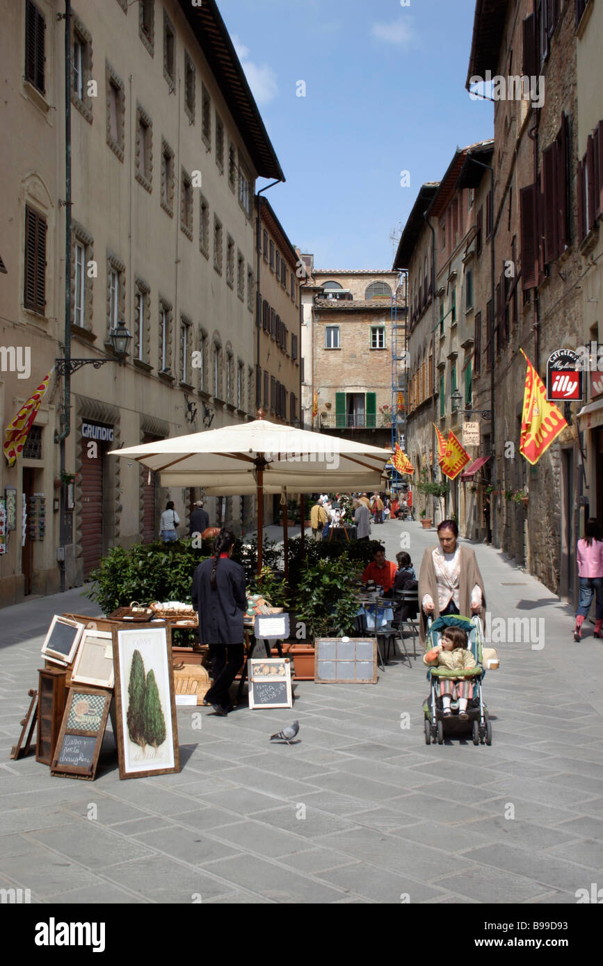 Street in historic town Market stalls Artwork on sale Woman with child ...