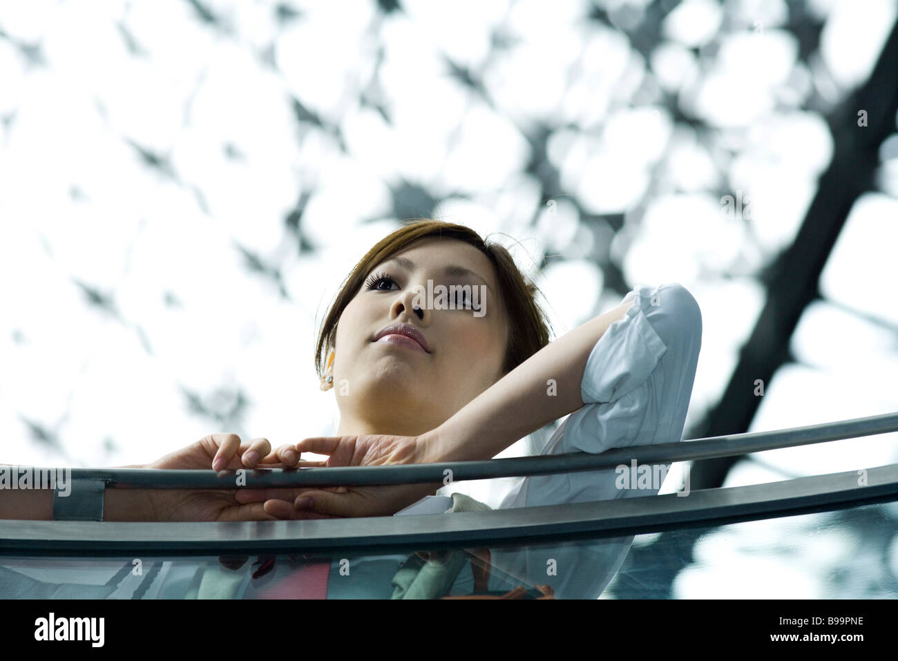 Young female leaning on railing, low angle view Stock Photo - Alamy