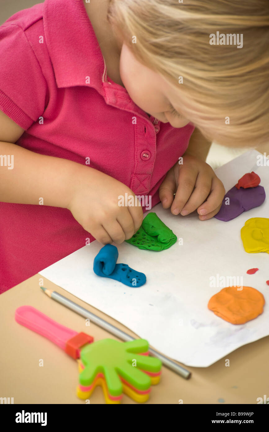 Little girl playing with clay Stock Photo - Alamy