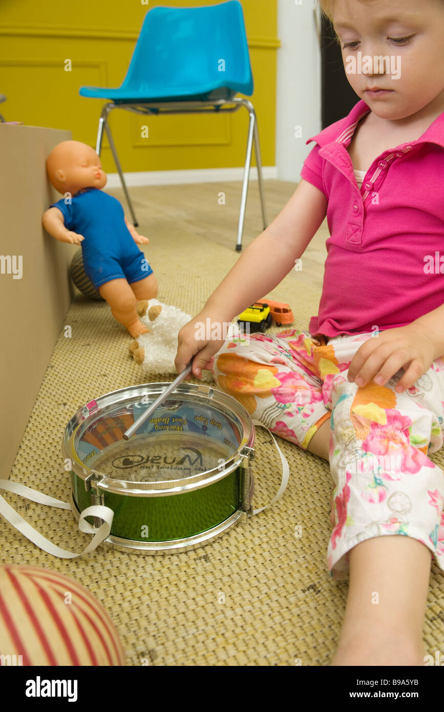 Little girl playing toy drum Stock Photo - Alamy