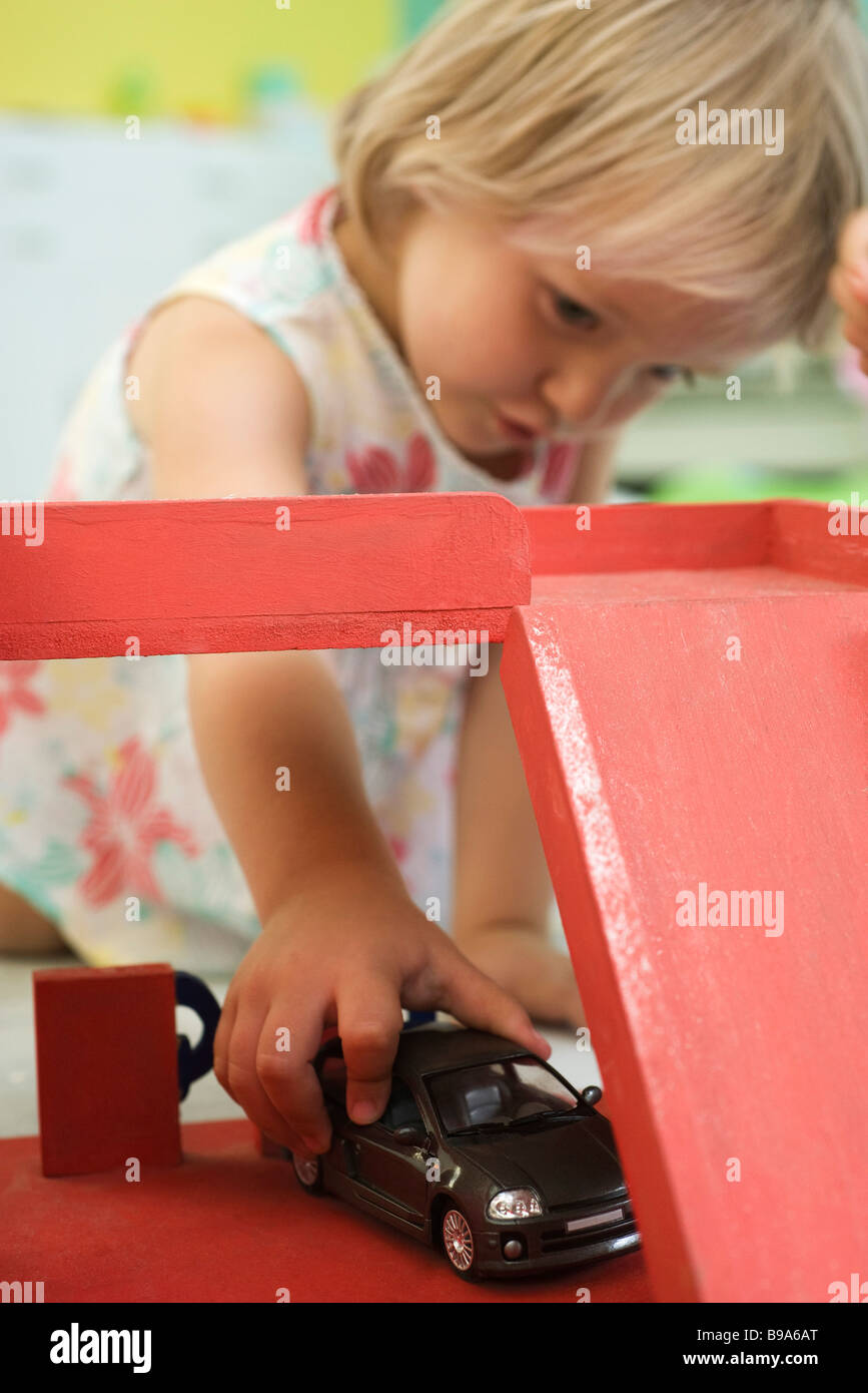Little girl playing with toy car Stock Photo - Alamy