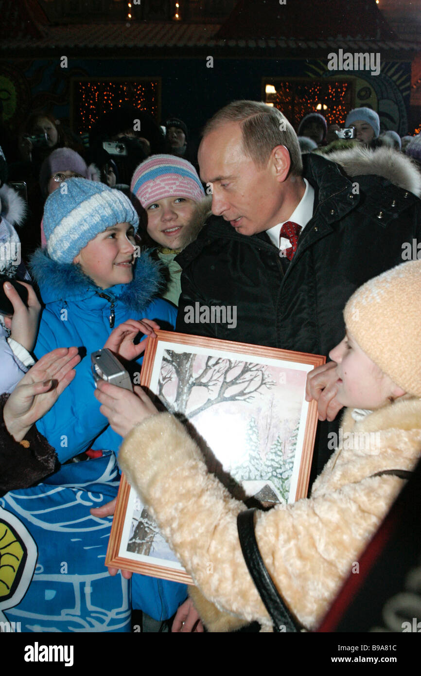 Russian President Vladimir Putin talks to children while visiting the ...