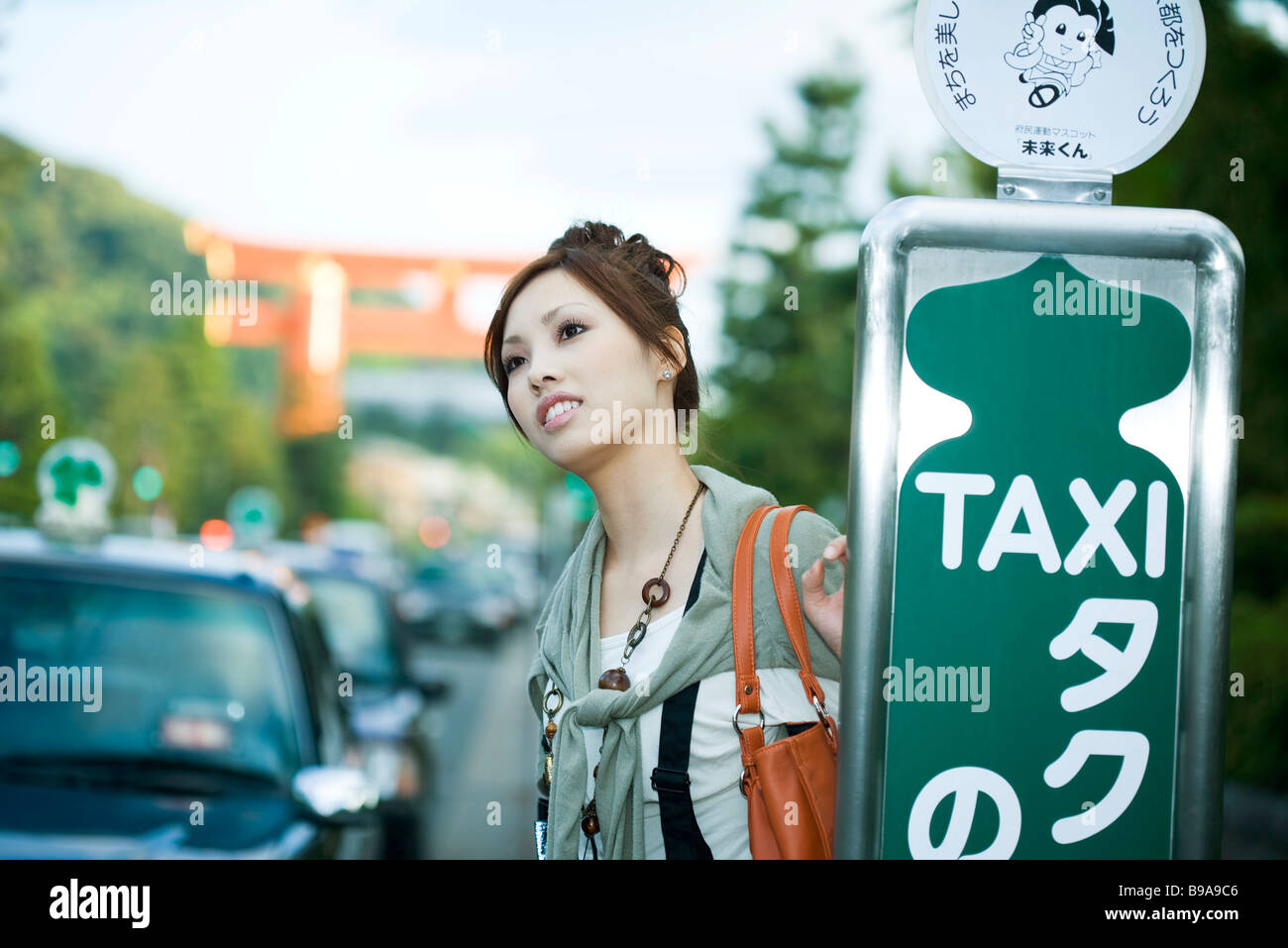 Young female waiting at taxi stand Stock Photo - Alamy