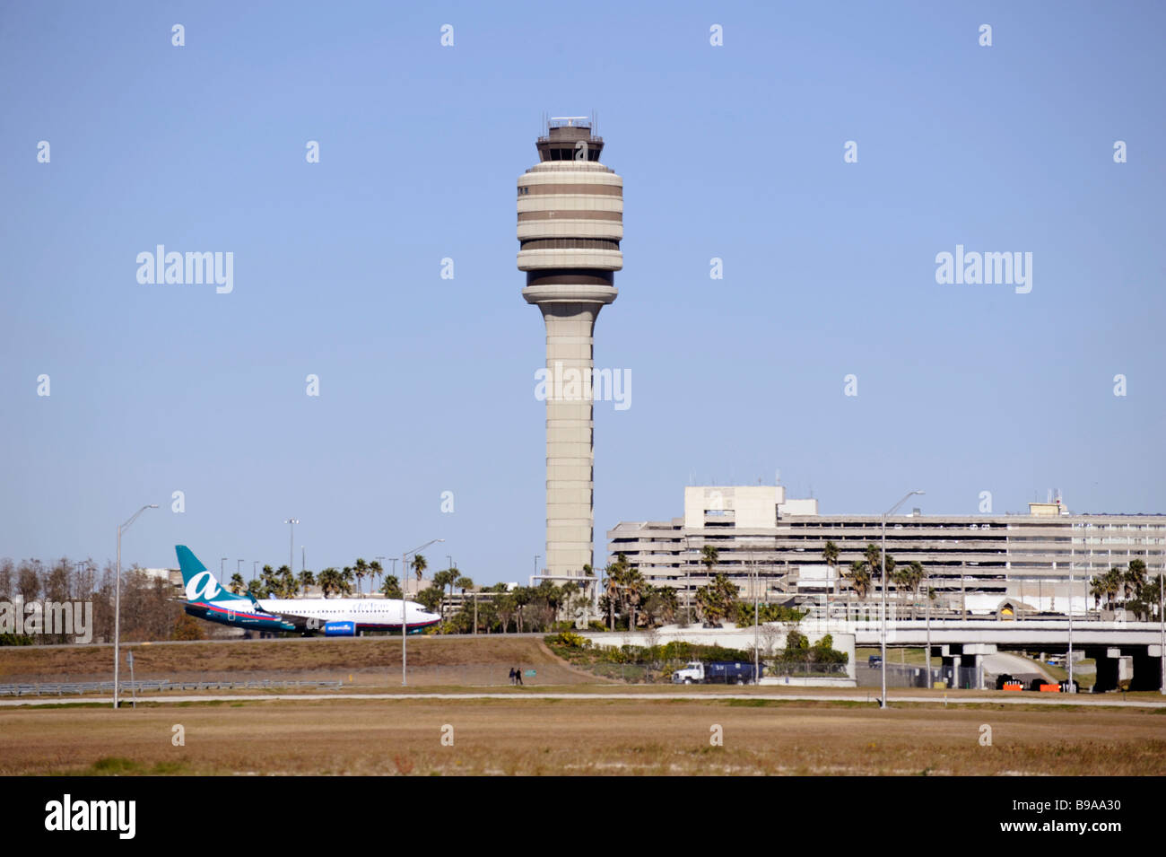 Airplane jet taxis on runway Control Tower at Orlando International ...