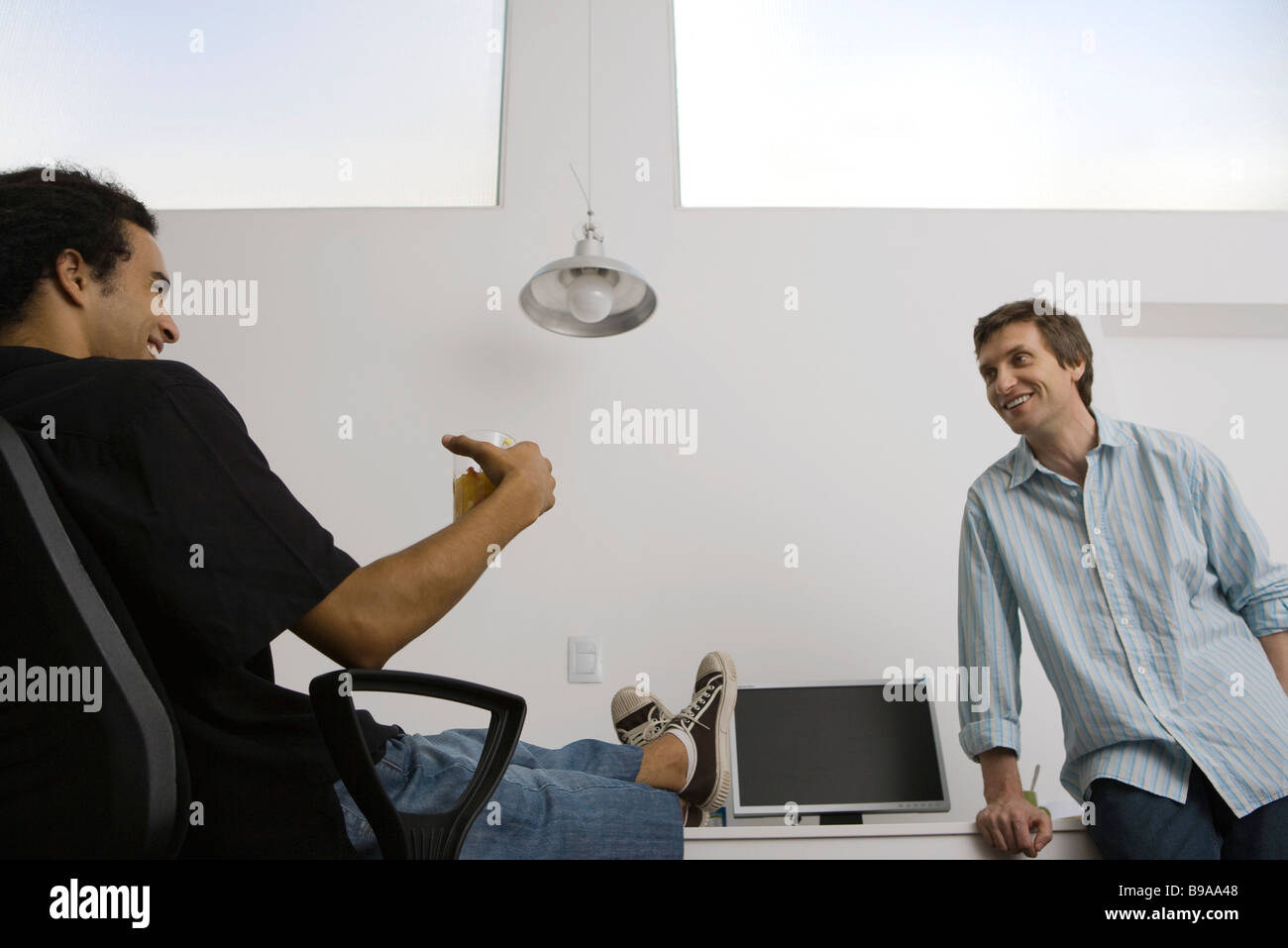 Men relaxing in casual office Stock Photo - Alamy