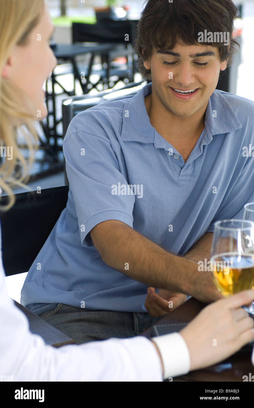 Young man sitting at outdoor cafe with friend Stock Photo - Alamy