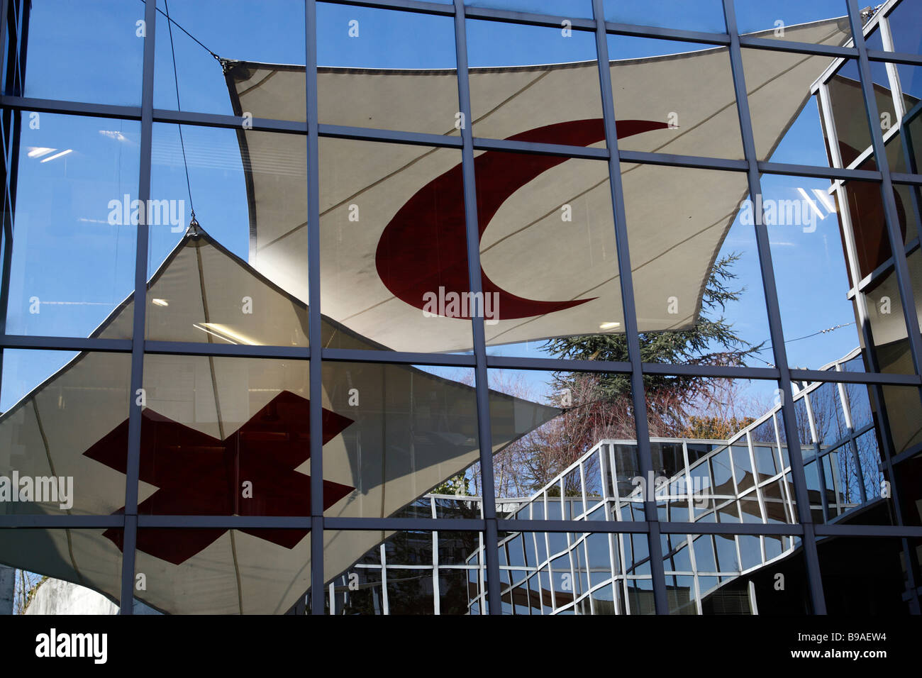 red cross & crescent emblems reflected in the glass building of the ...